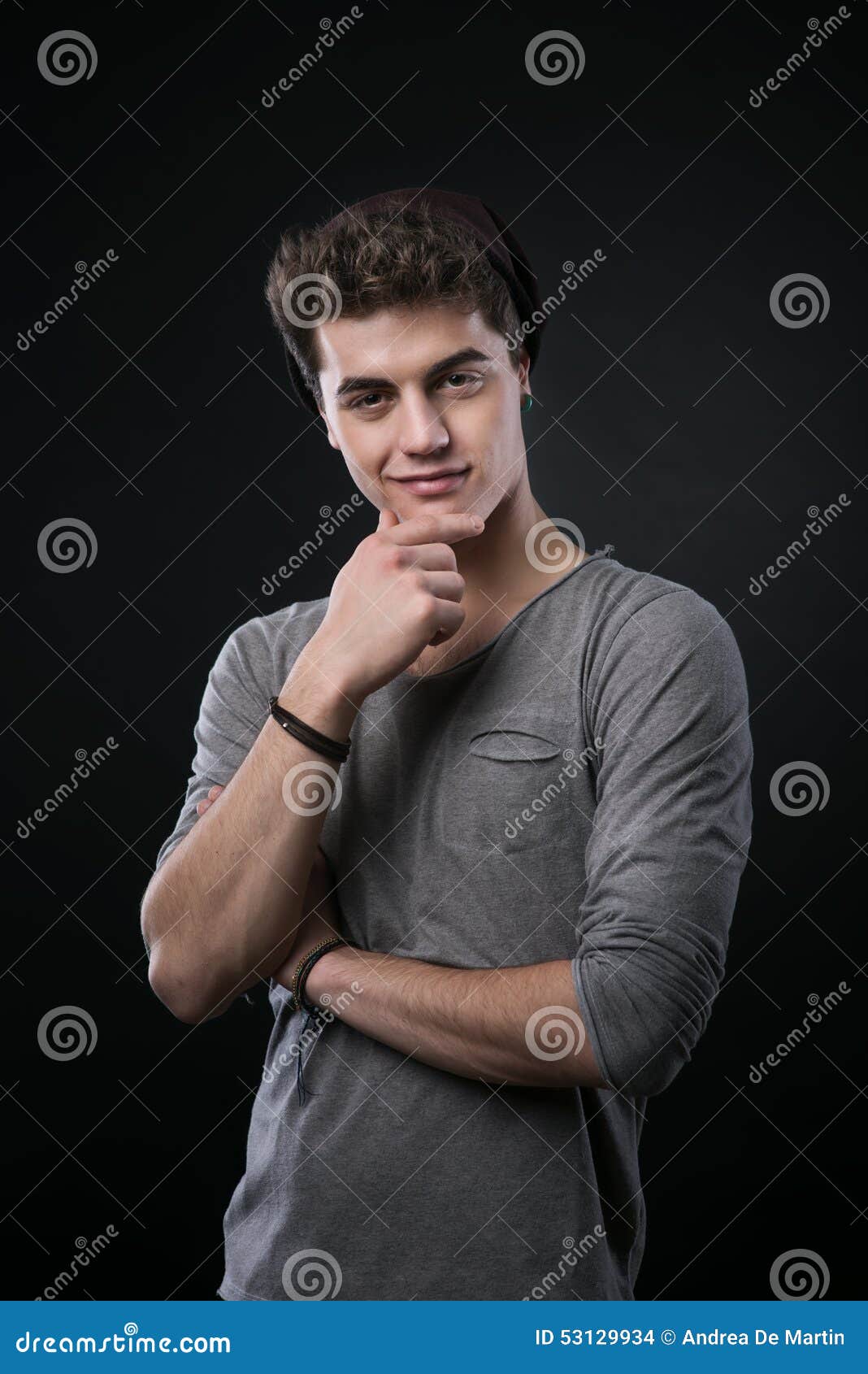 Smirking young man posing stock photo. Image of hand - 53129934
