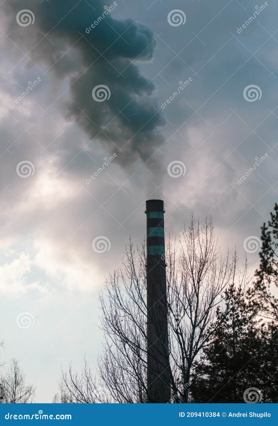 Smoke from Chimneys at the Plant Behind the Branches of a Tree Stock ...
