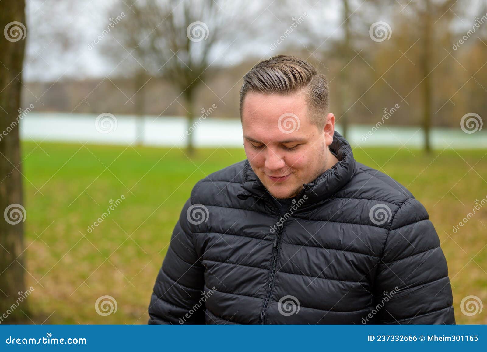 Sniggering Young Man Looking Down with a Smile Stock Photo - Image of ...