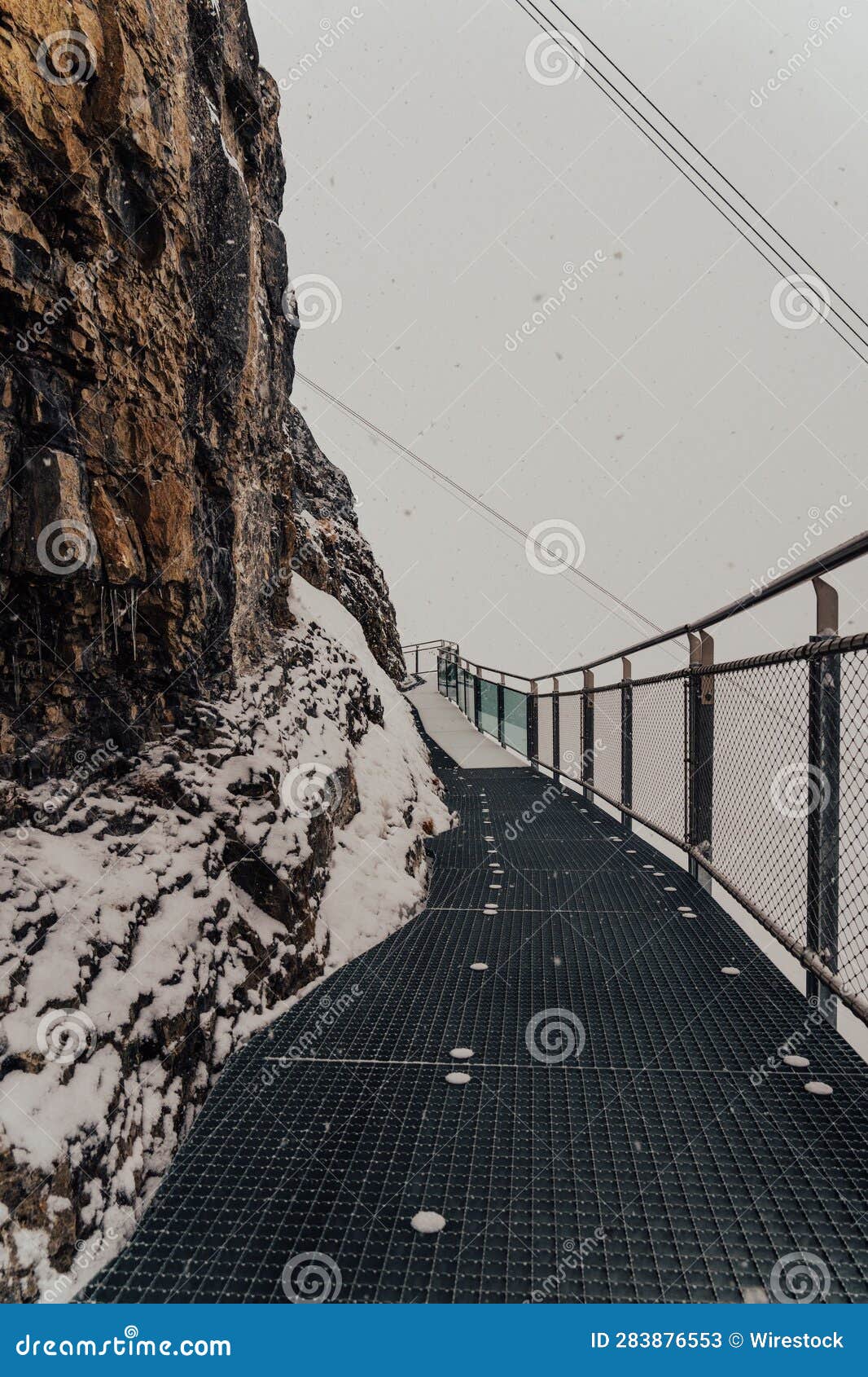 Snow-covered Elevated Walkway with Rocky Terrain Surrounding it Stock ...