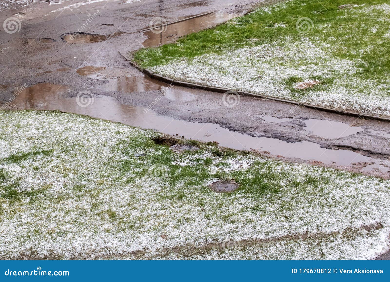 Snow on Green Grass and Puddle on Road Stock Photo - Image of grass ...