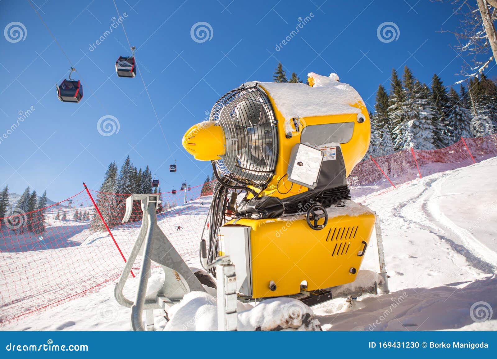 The Snow Machine is Located on the Ski Slope. it is a Beautiful Day on ...
