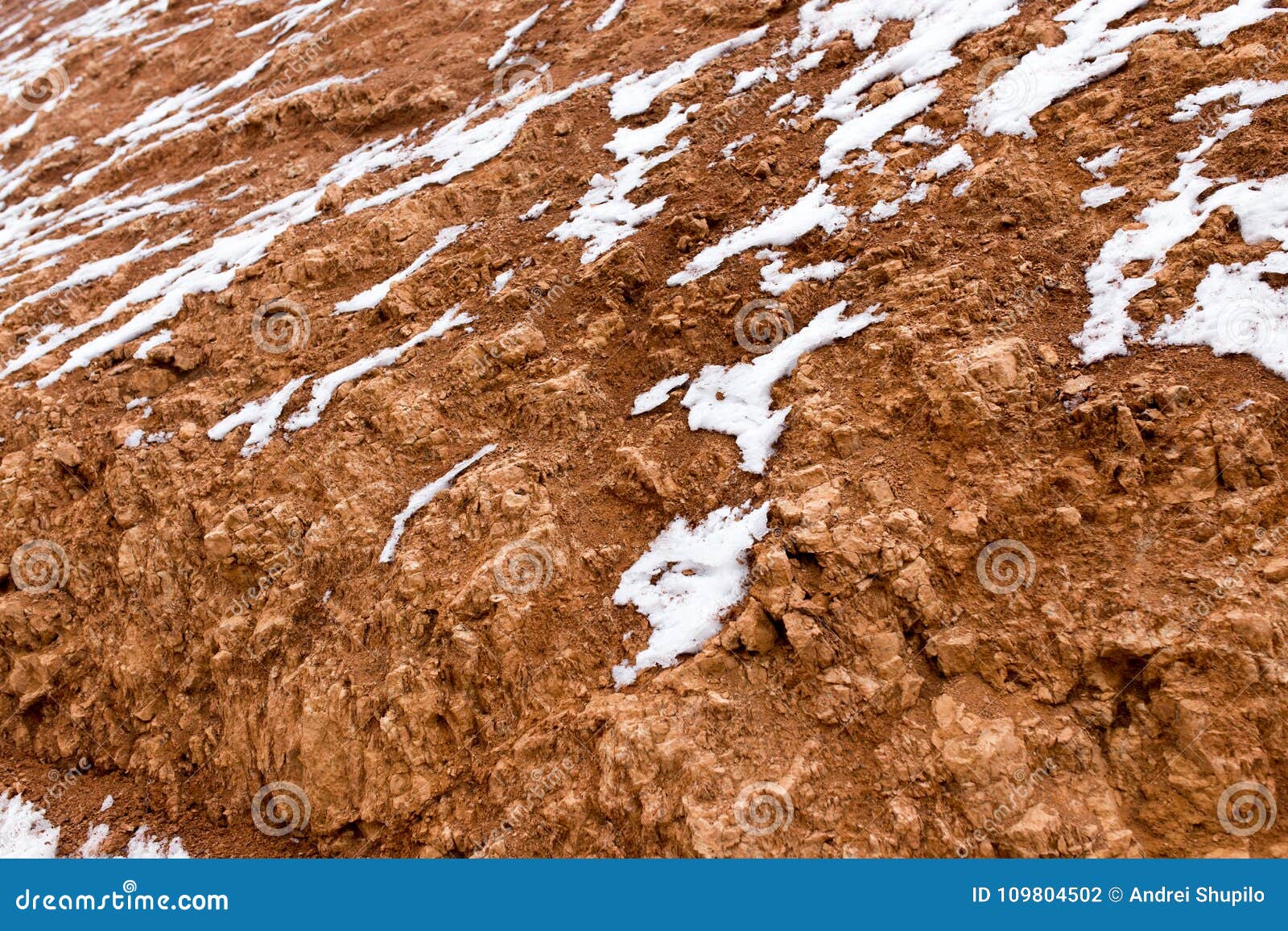 Snow on red clay in nature stock photo. Image of sand - 109804502