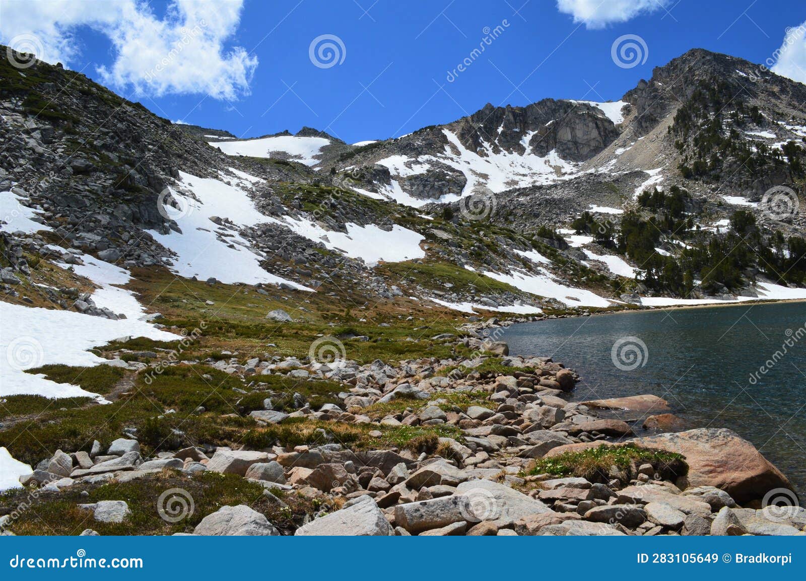 Snowfields, Mountain Peaks, and Rocks Surrounding a High Mountain Lake ...