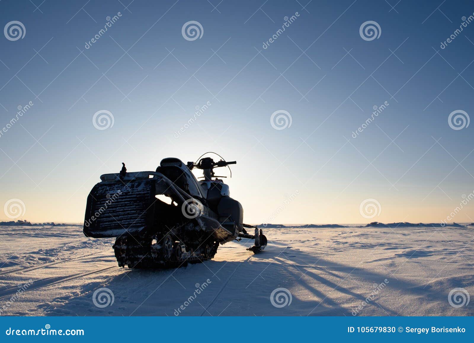 A Snowmobile Stands on the Snow at Sunset. Stock Photo - Image of cold ...