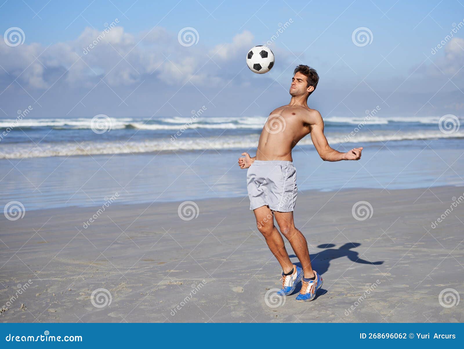 Soccer on the Beach. a Young Muscular Playing Soccer on the Beach ...