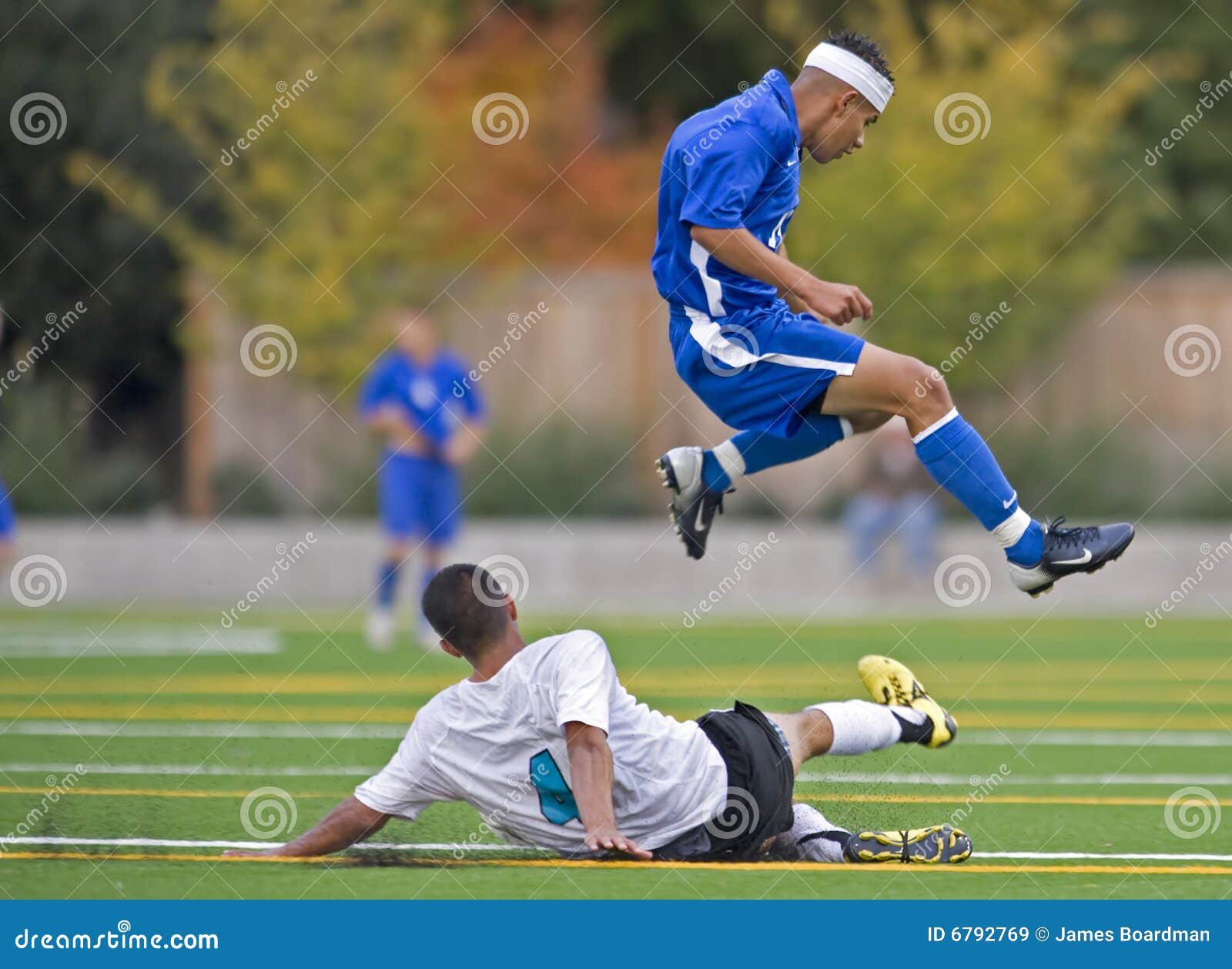 Soccer Player Leaping Over Fallen Athlete Editorial Stock Image - Image ...