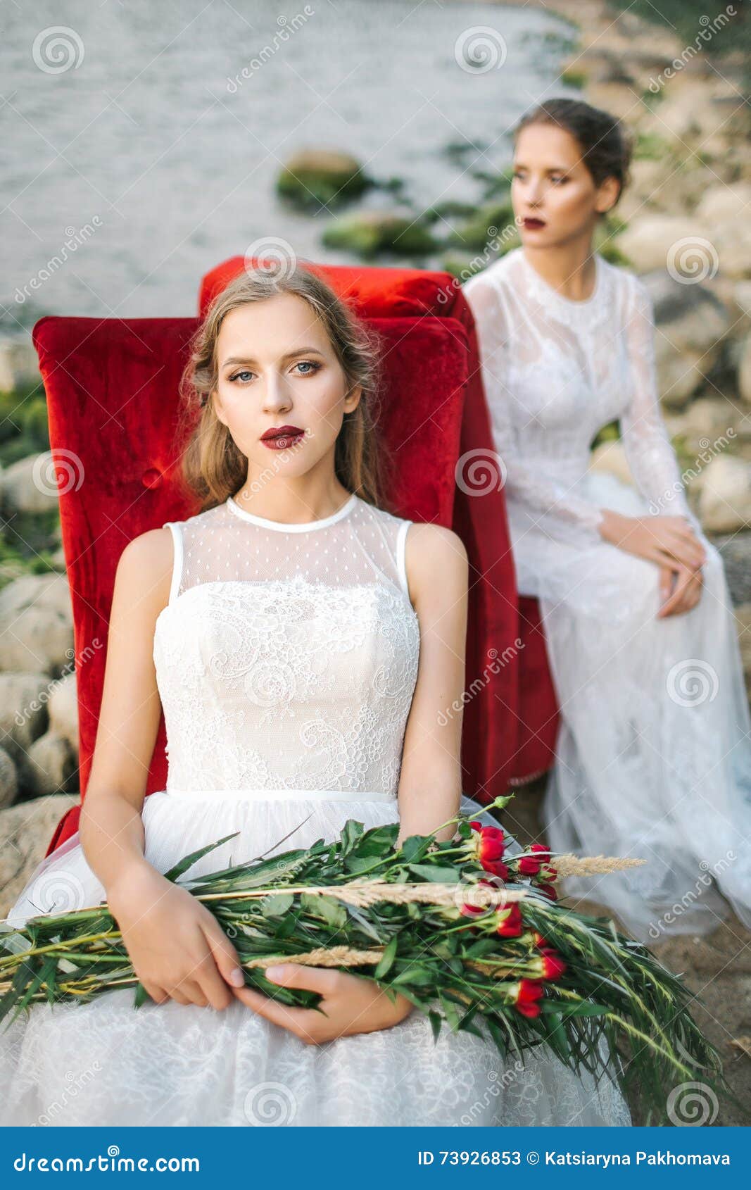 Soeurs Jumelles Dans La Robe De Mariage Sur Le Bord De La Mer Image