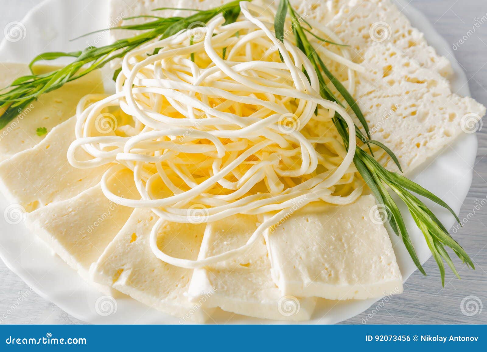 Soft Cheese Chechil and Guda on Plate with Herbs on Wooden Table. Close ...