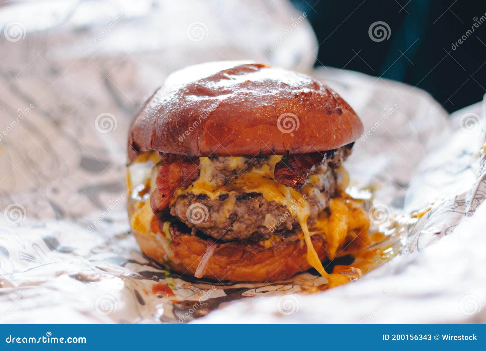 Focus To A Cheesy Beef Burger With French Fries With A Woman ...