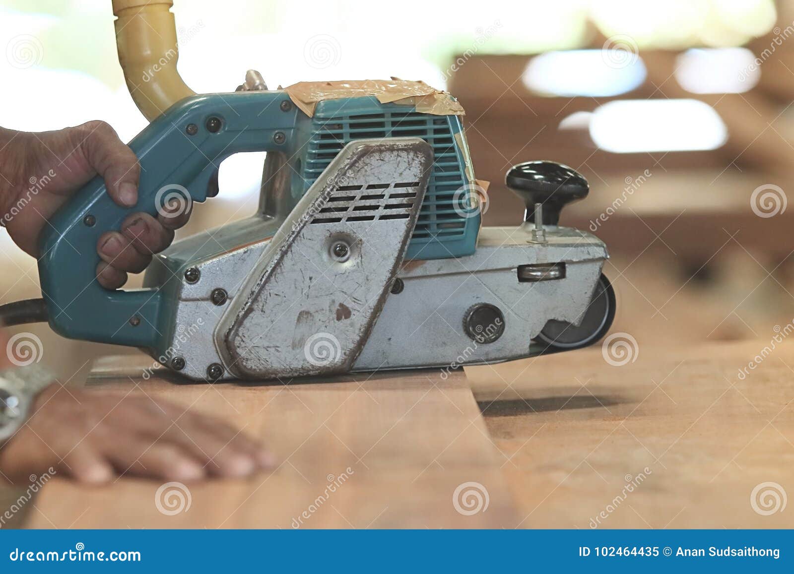 Soft Focus Shot of Belt Sander on a Piece Wood with Hands of Worker ...