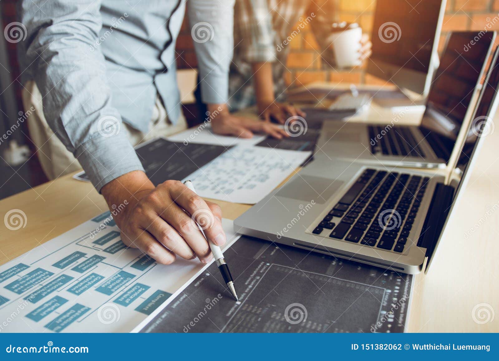 Software Developer Is Pointing To The Paper Working And Analyzing Together The Code Written Into