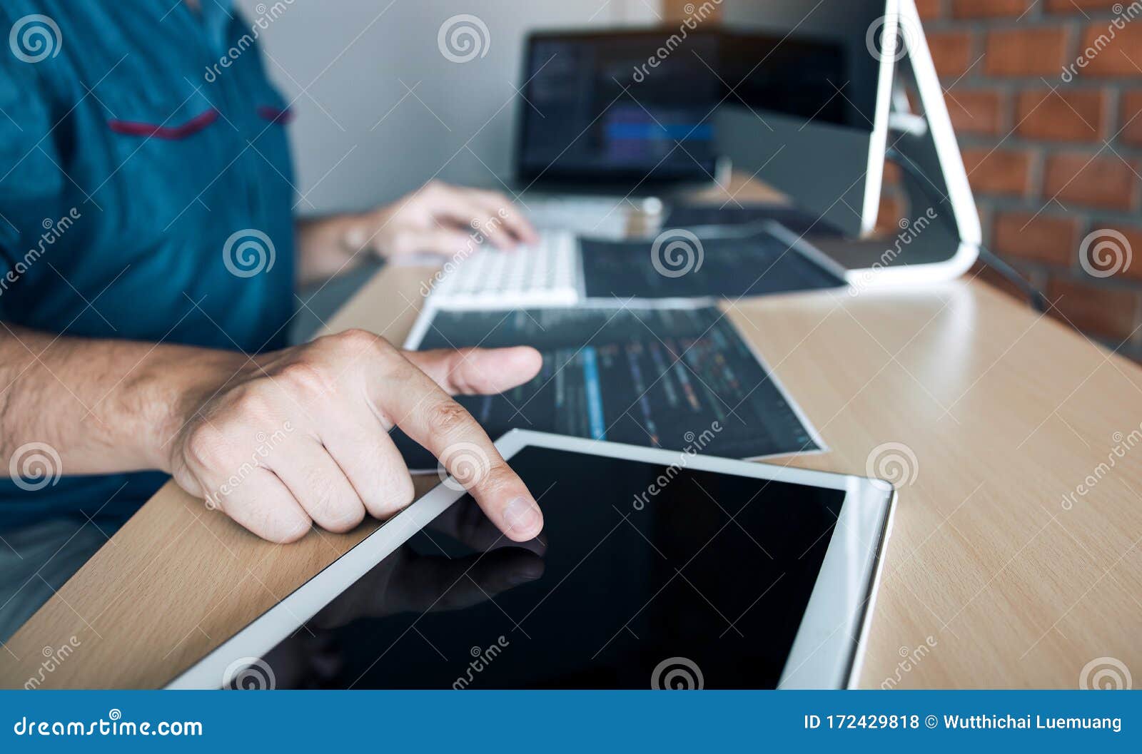 Software Developer Is Pointing To The Paper Working And Analyzing Together The Code Written Into