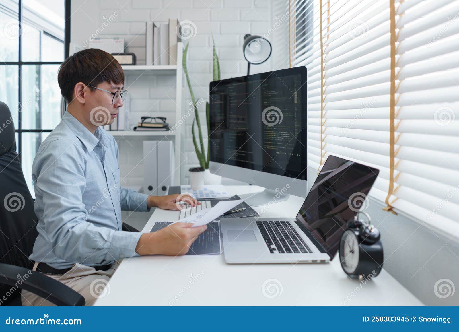 Software Development Concept, Male Programmer Read Data on Document while Programming on ...