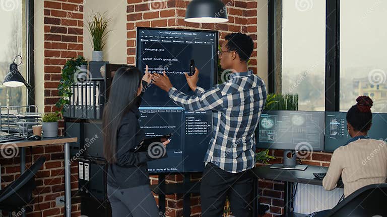 Software Engineers Analyzing Code on Wall Screen Tv Comparing Errors Using Digital Tablet Stock ...
