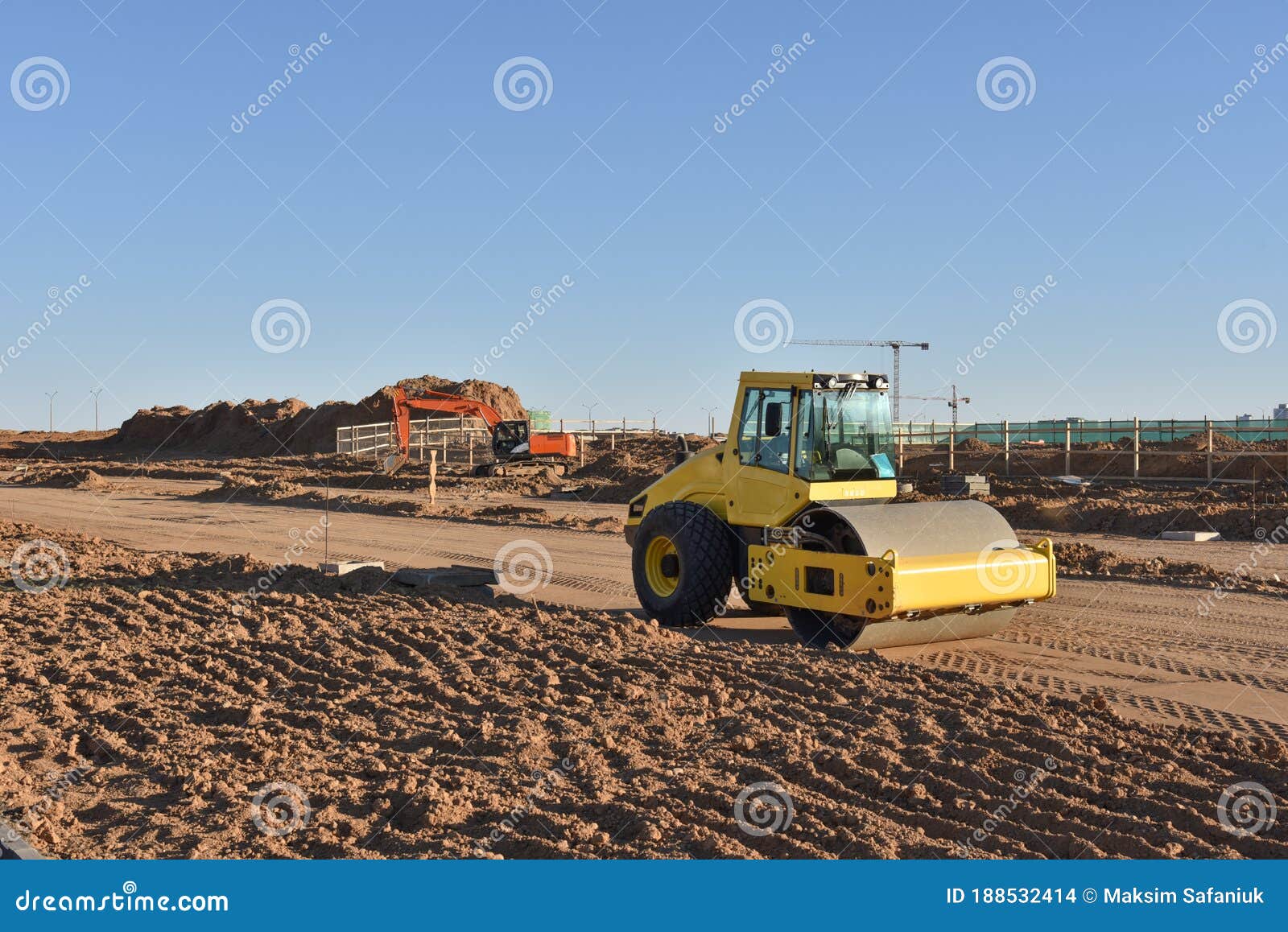 Soil Compactor the Leveling Soil at Construction Site. Excavator and ...