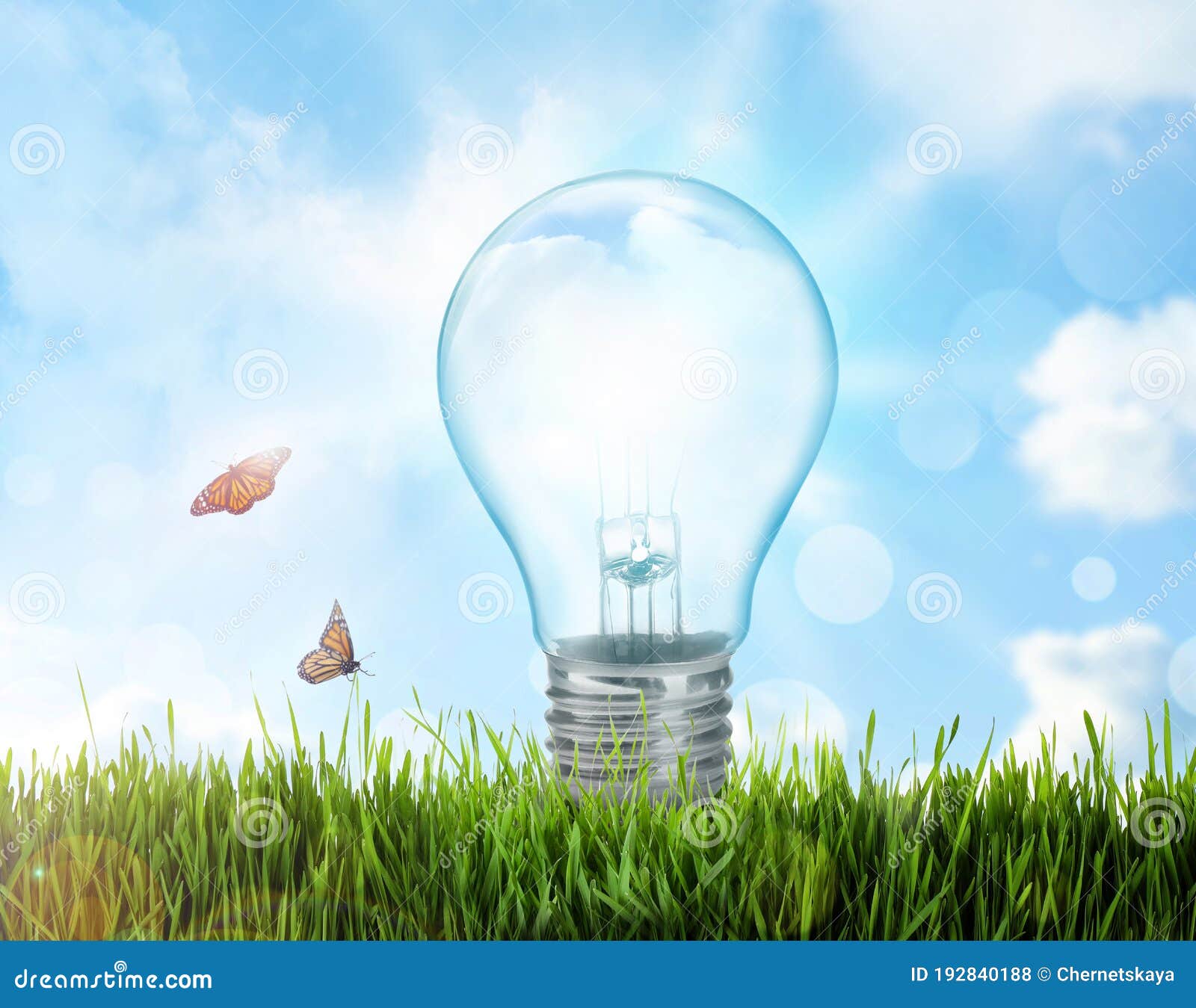 Solar Energy Concept. Glowing Light Bulb in Grass and Blue Sky with ...