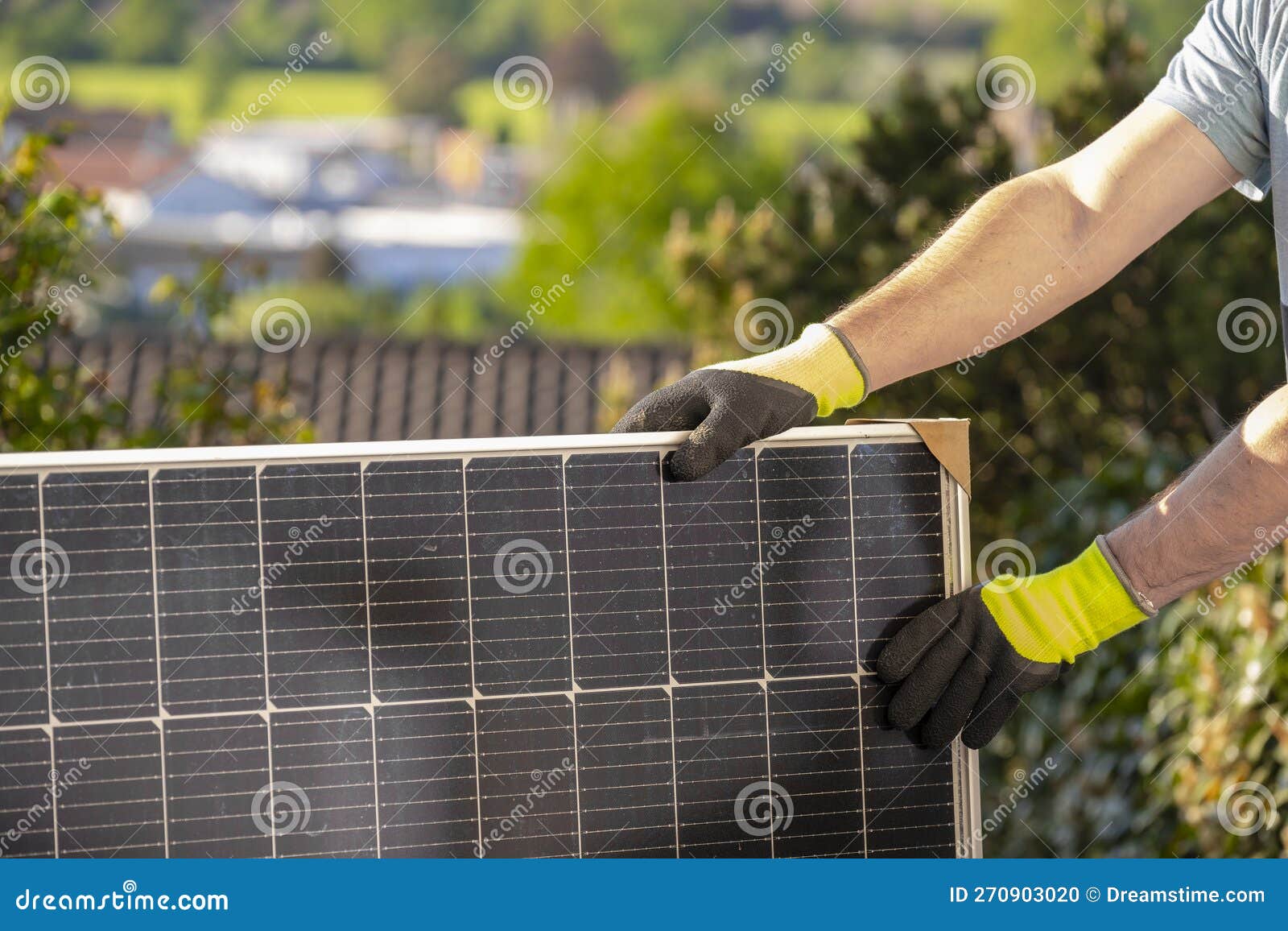 Solar Energy. Solar Panel in the Hands of a Worker on Houses Background ...