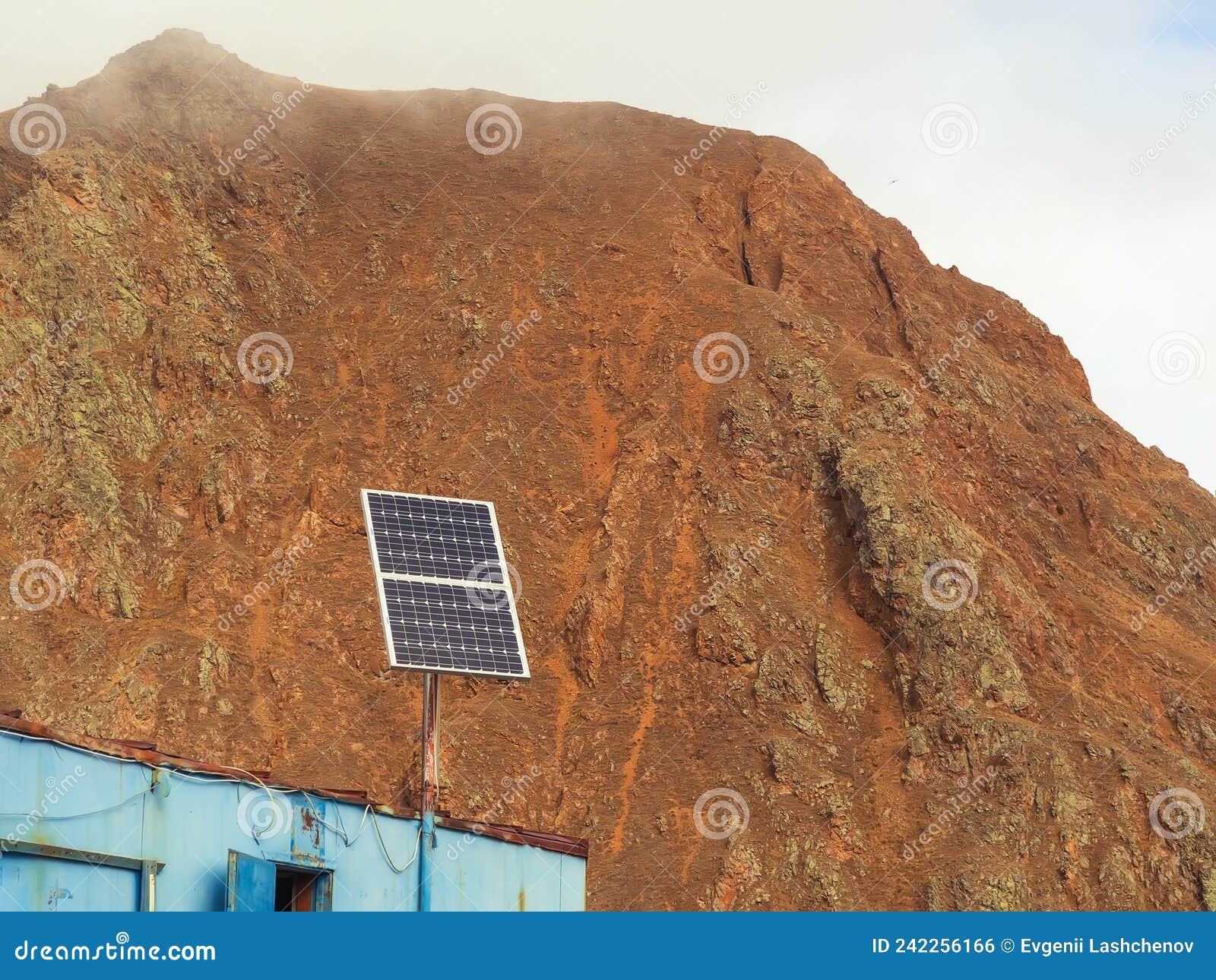 Solar Panel Near a Steep Red Cliff Against a Cloudy Sky in the ...