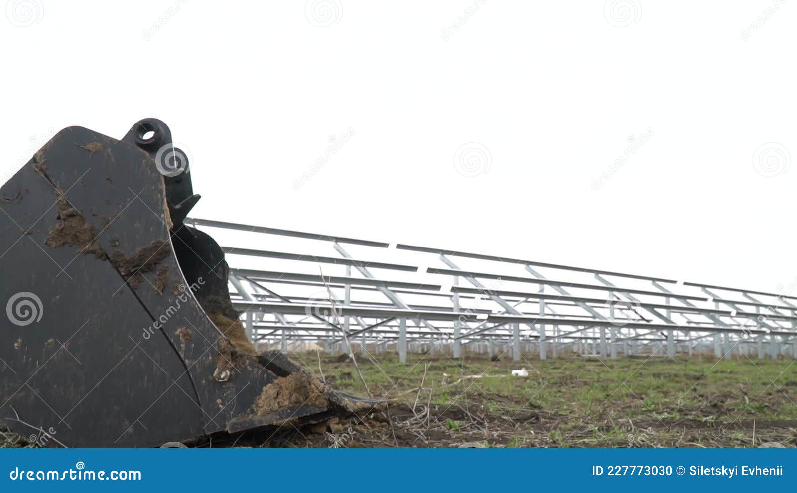 Solar Panel Racks in the Background of a Massive Excavator Bucket ...
