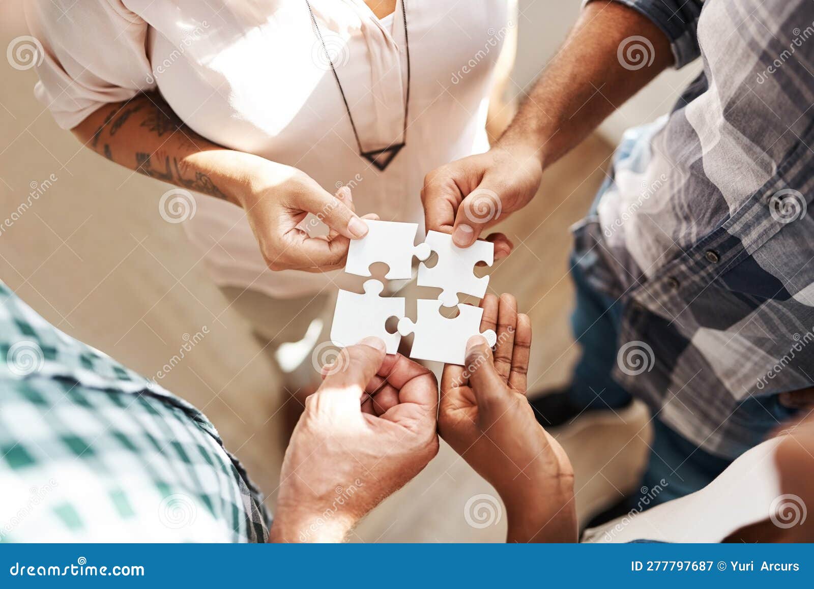 The Solution is always Teamwork. a Group of Creatives Connecting Pieces ...