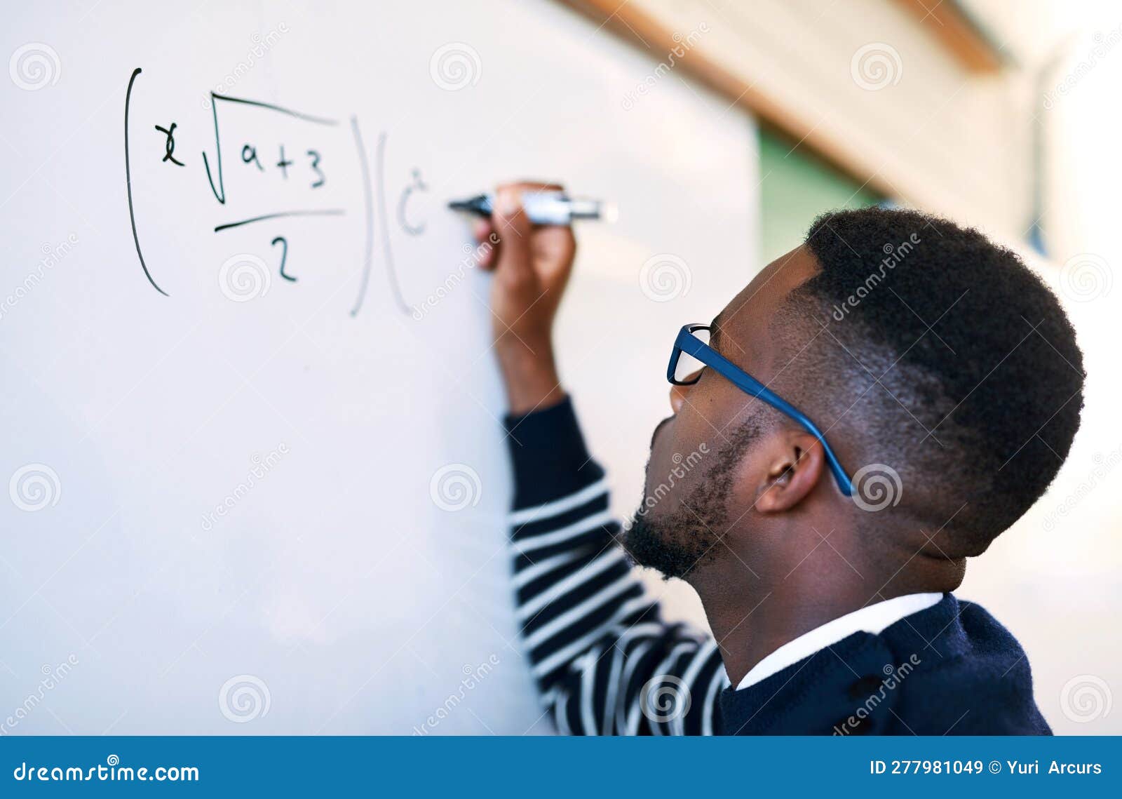 Solving the Equation. a Young Man Writing on a Whiteboard in a ...