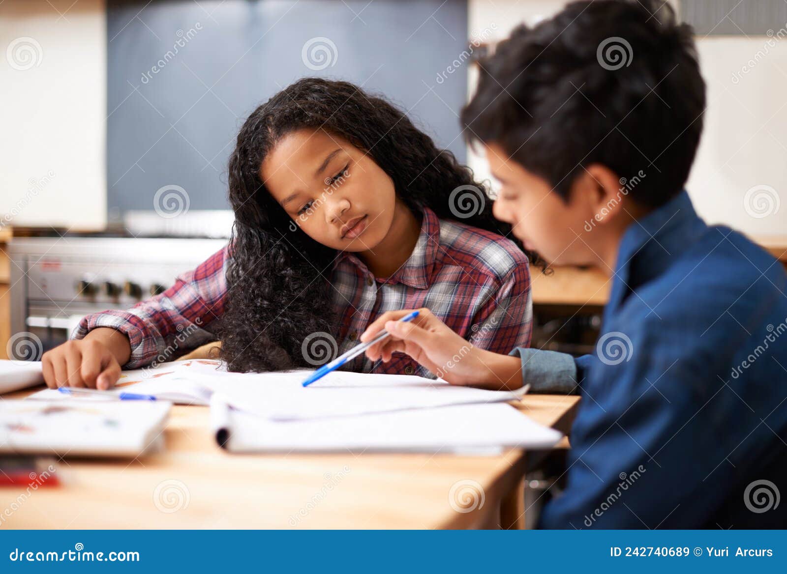 Solving Their Homework Together. Shot of Two Young Students Studying ...