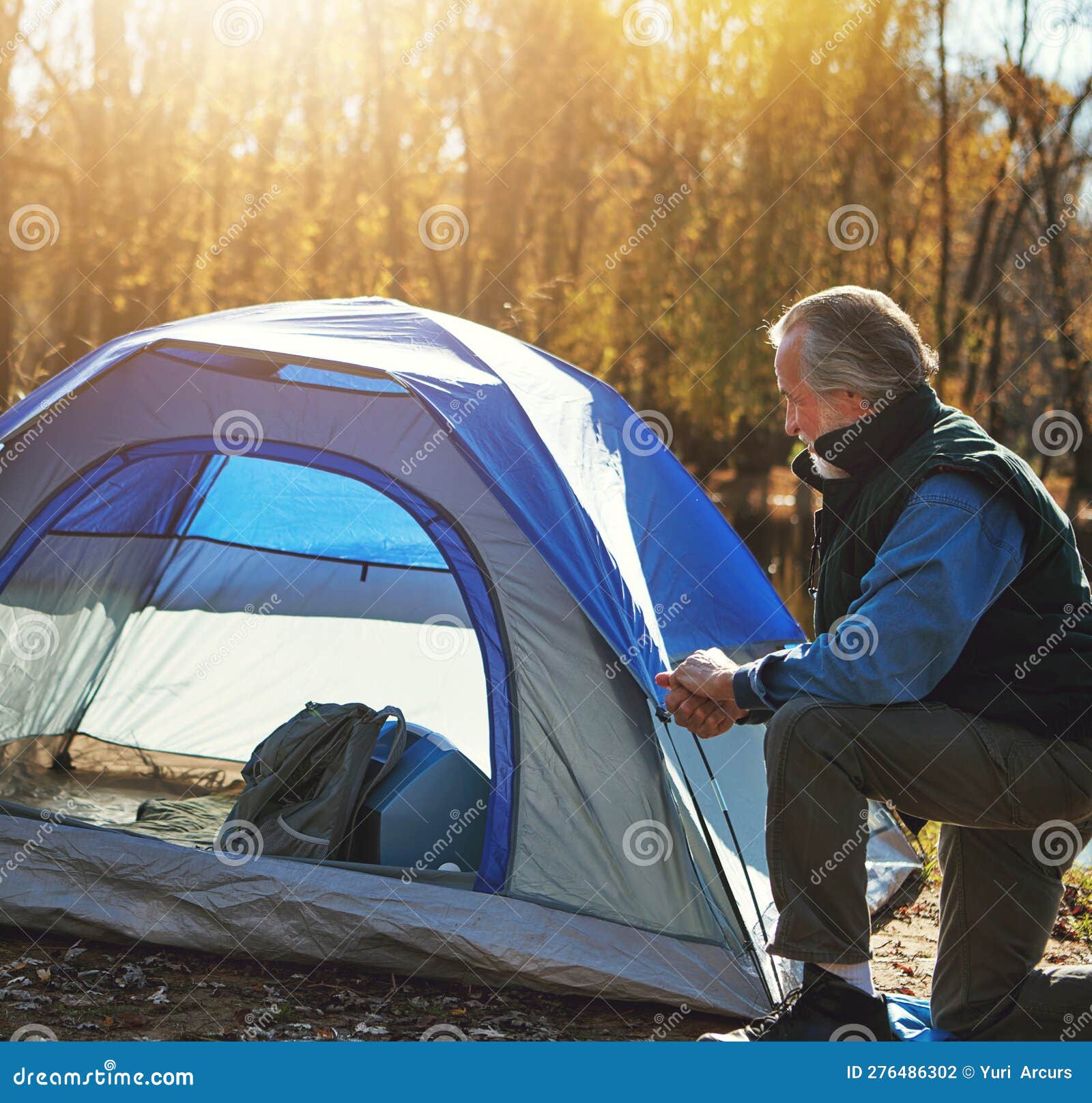 Some Call Him the Camping Master. a Senior Man Setting Up a Tent while ...