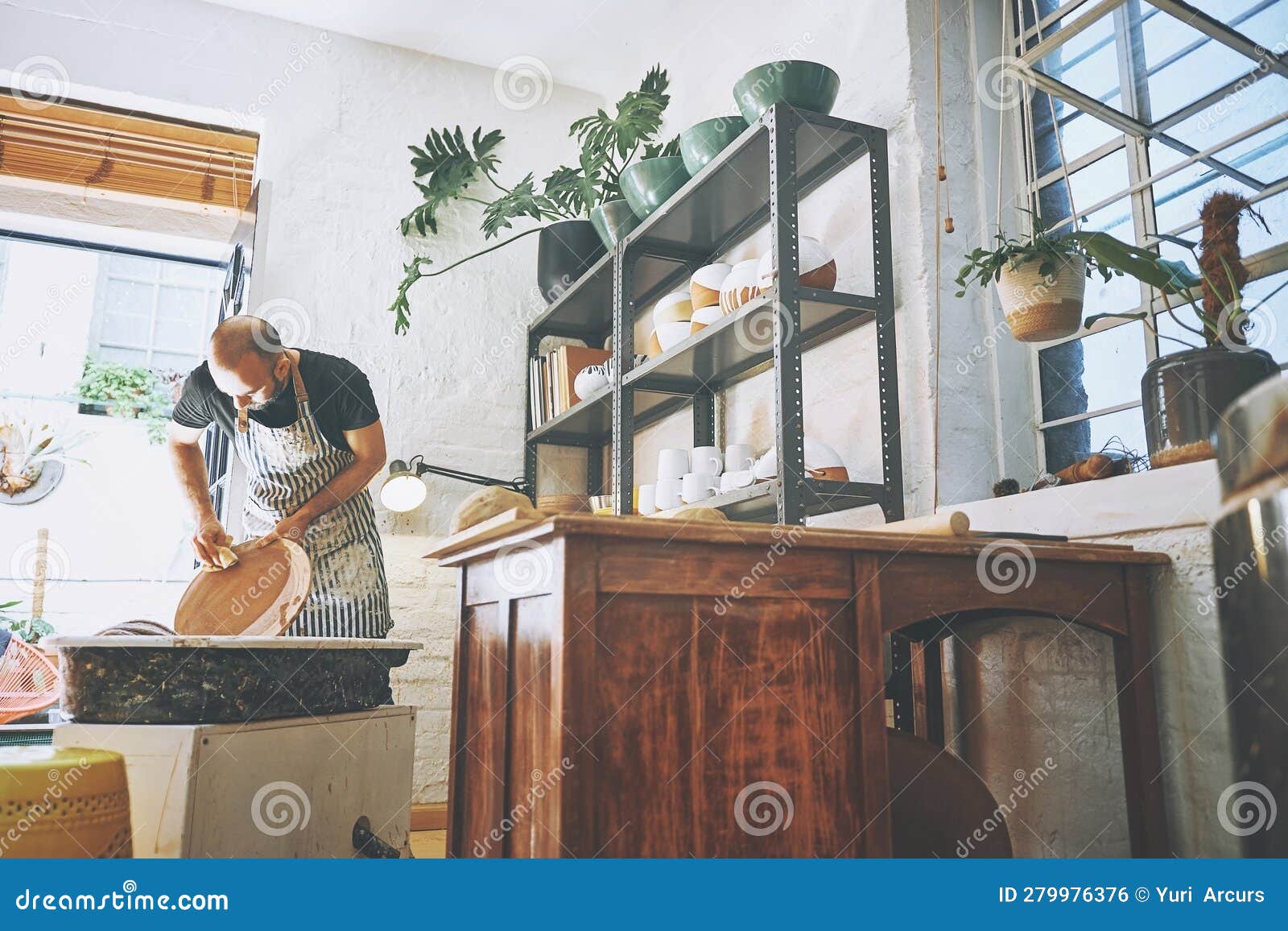 Some Call it a Studio, he Calls it Home. a Young Man Cleaning a Pottery ...