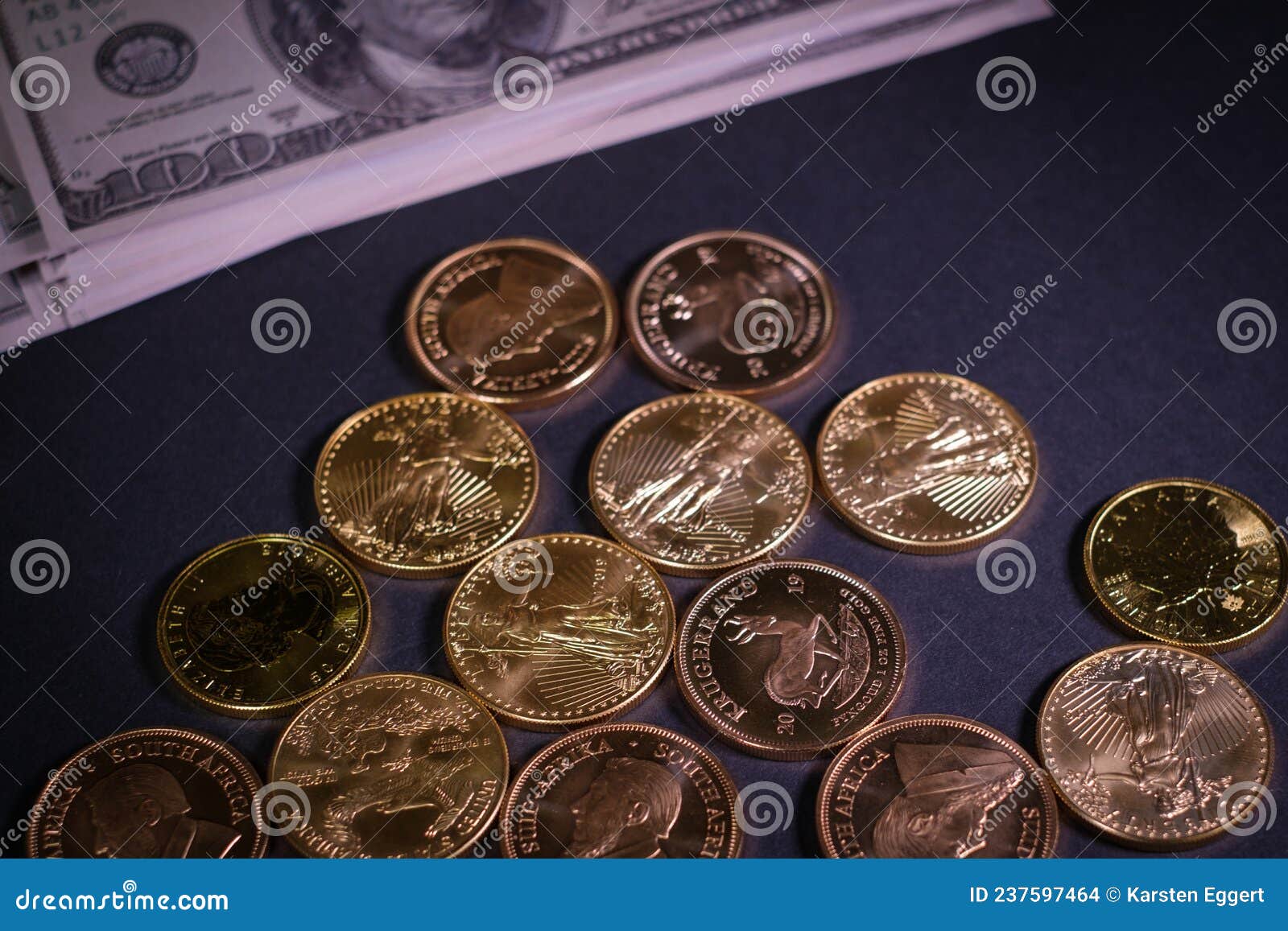 Some Gold Coins Lie Spread Out Next To a Stack of Dollar Banknotes ...