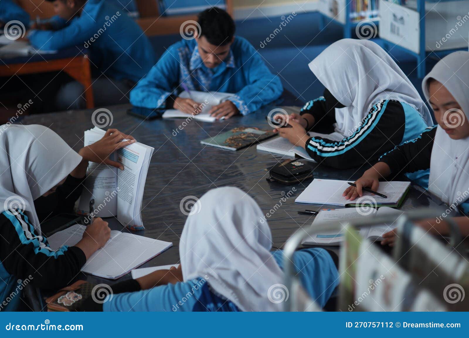 Some Students are Studying at a Table in the Library Editorial ...