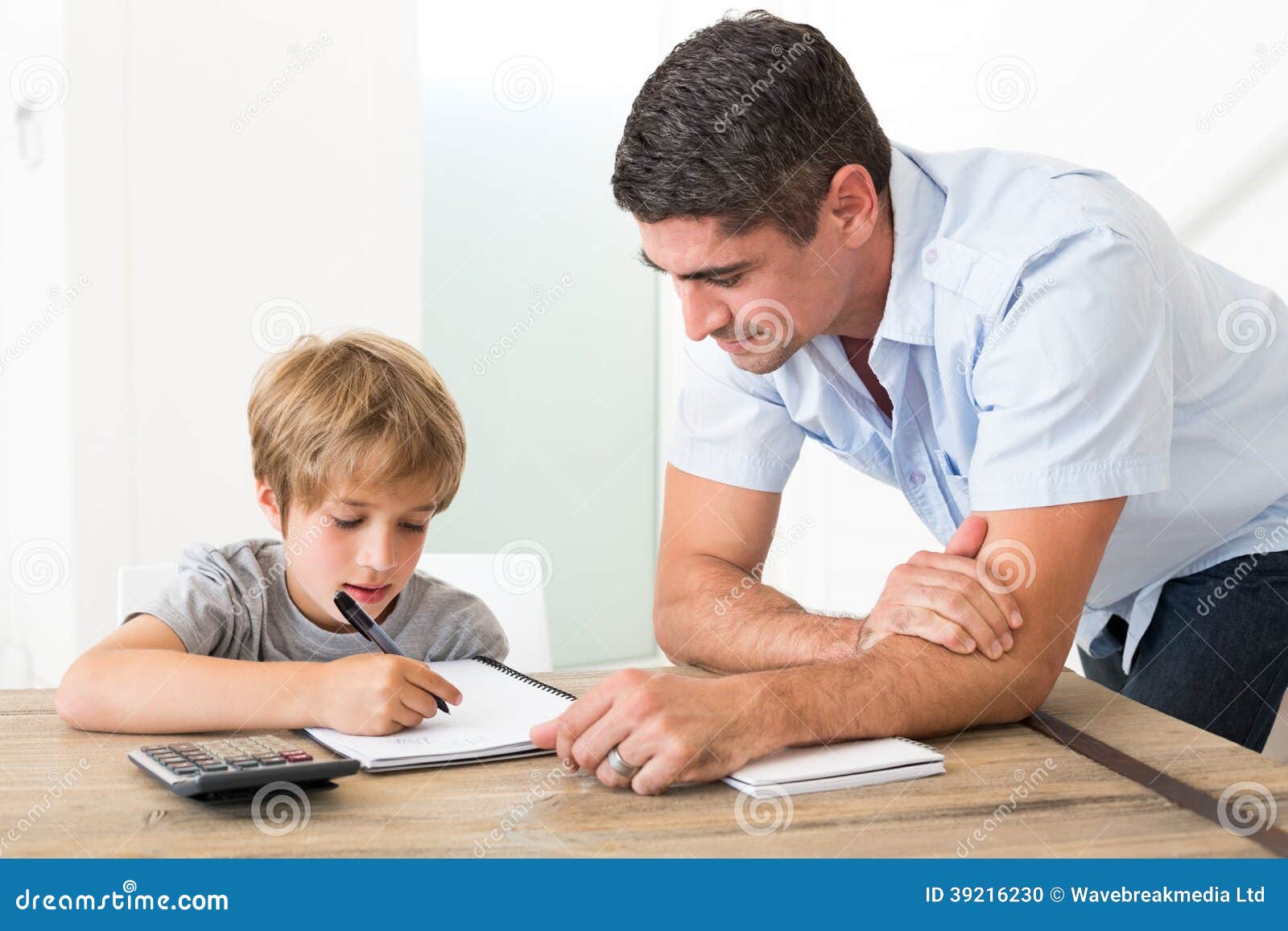 Son Doing Homework while Father Standing by Stock Photo - Image of ...