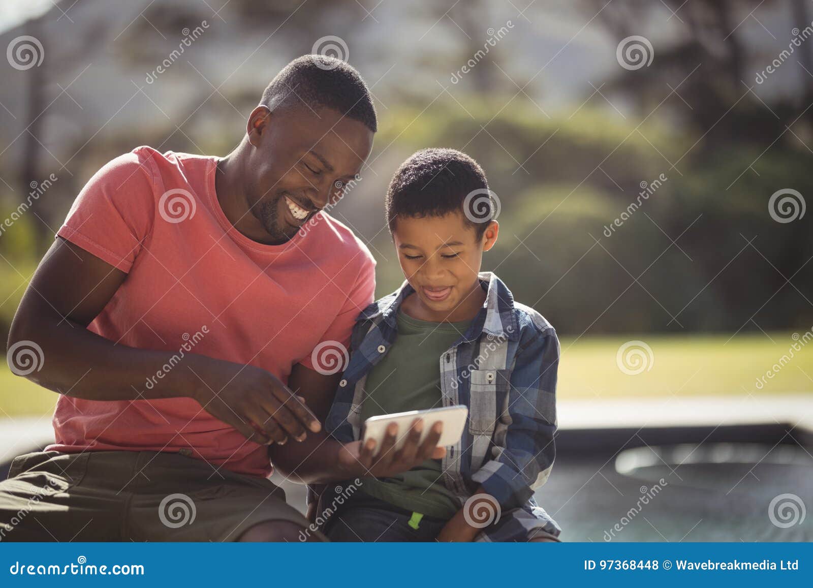 Son and Father Using Mobile Phone Near Poolside Stock Photo - Image of ...