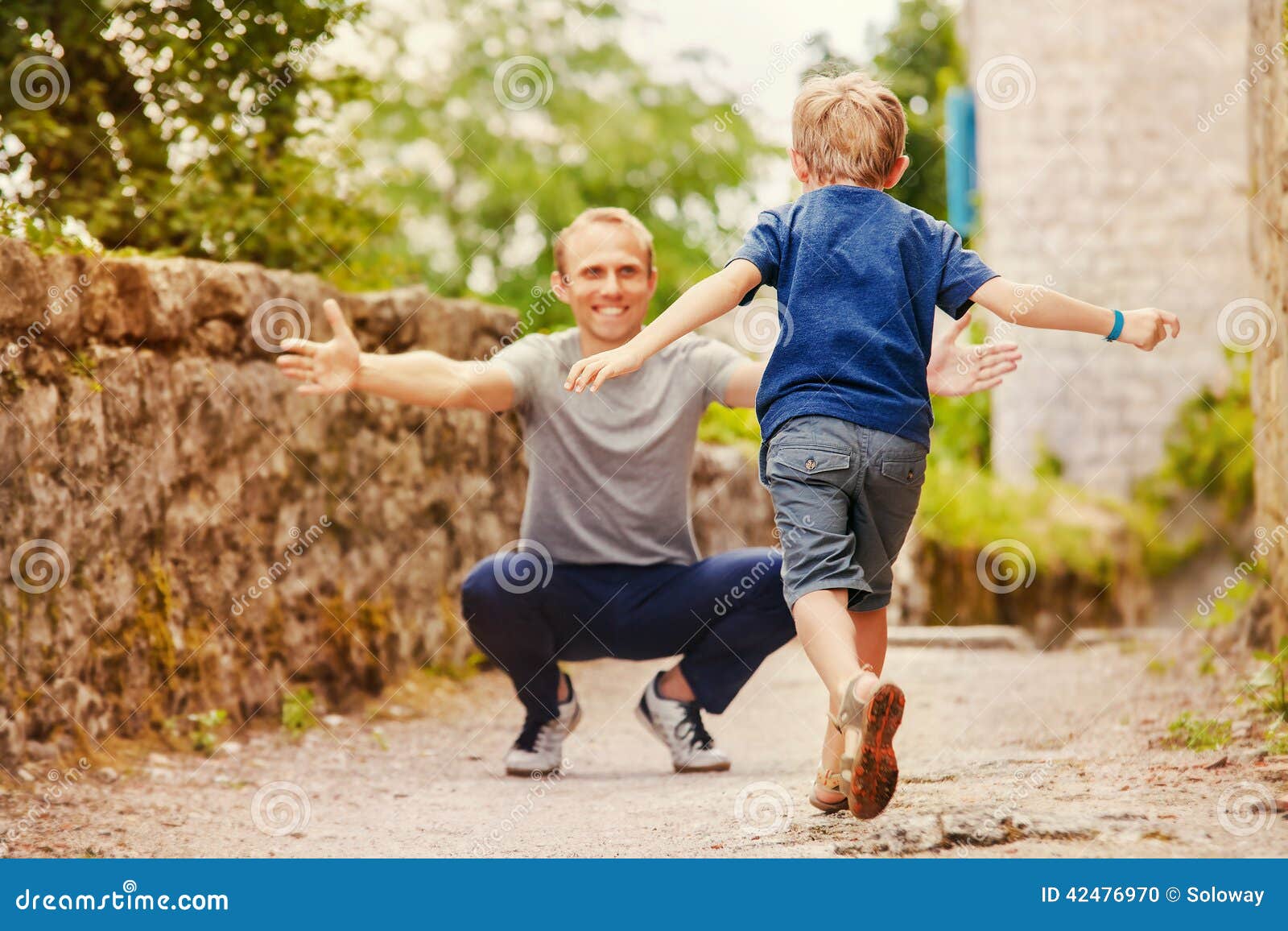 Son runs to daddy s arms stock photo. Image of male, grass - 42476970