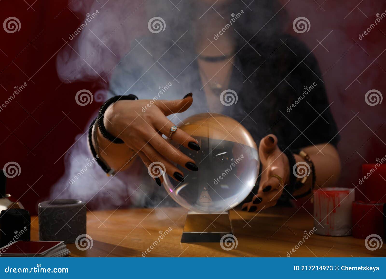 Soothsayer Using Crystal Ball To Predict Future At Table Indoors
