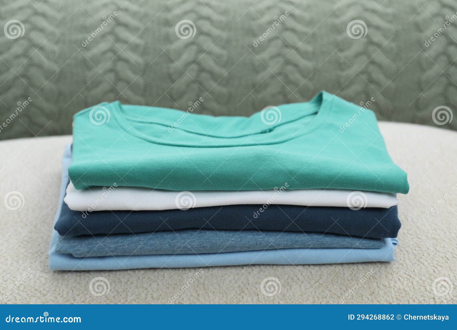 Sorting and Organizing. Stack of Different Folded Clothes on Ottoman ...