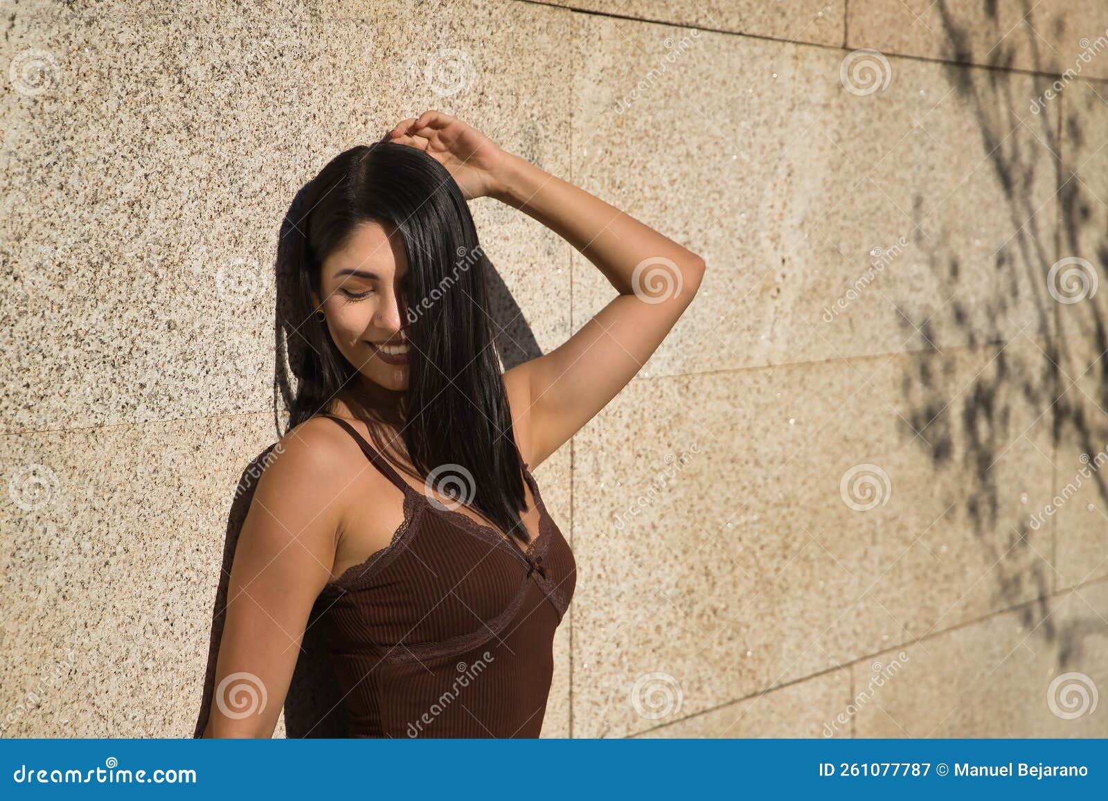 South American Woman Young And Beautiful Brunette Wearing A Brown Dress Posing Leaning