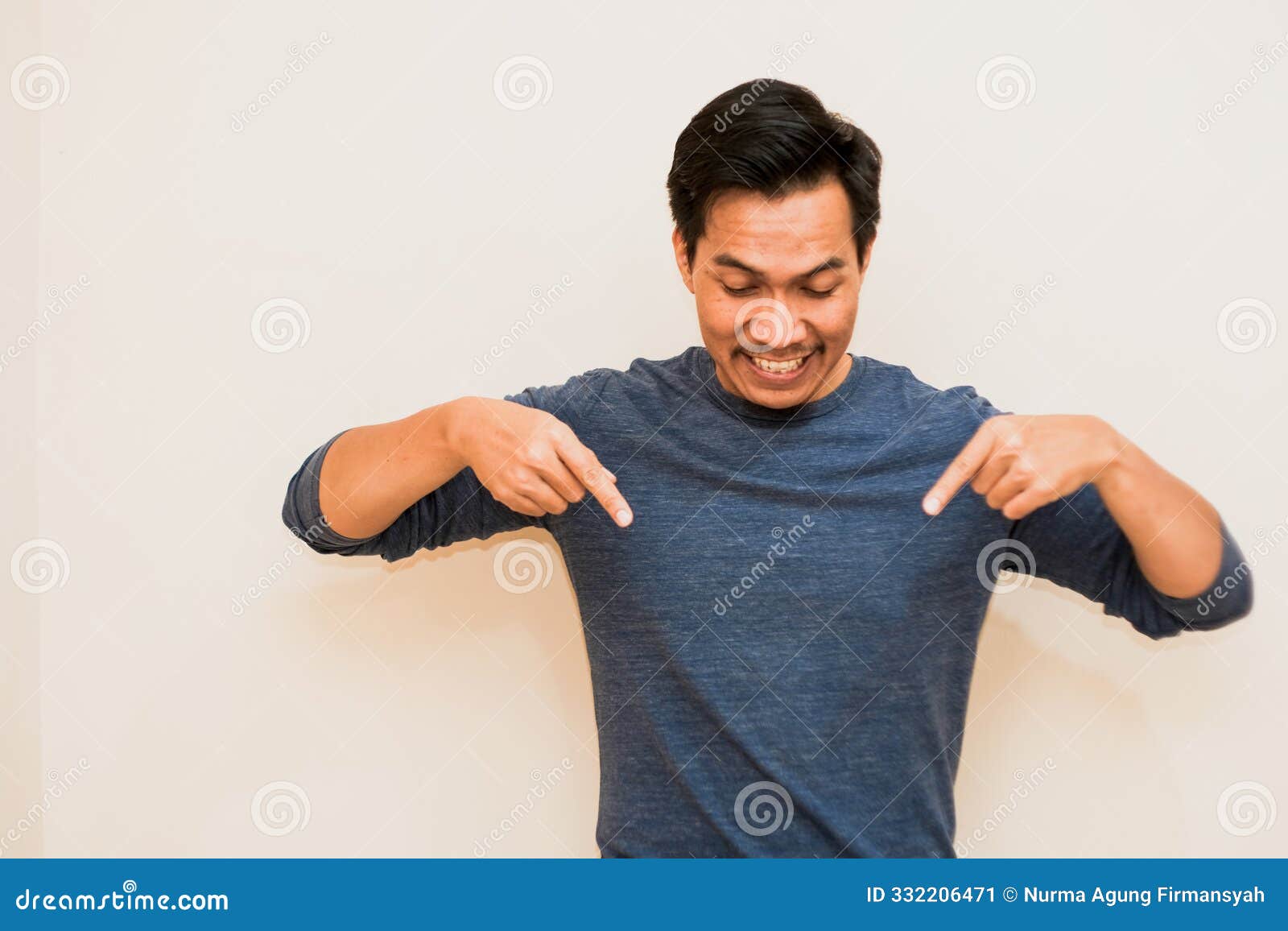 Southeast Asian Man Smiling Looking Down and while Two Hands Pointing ...