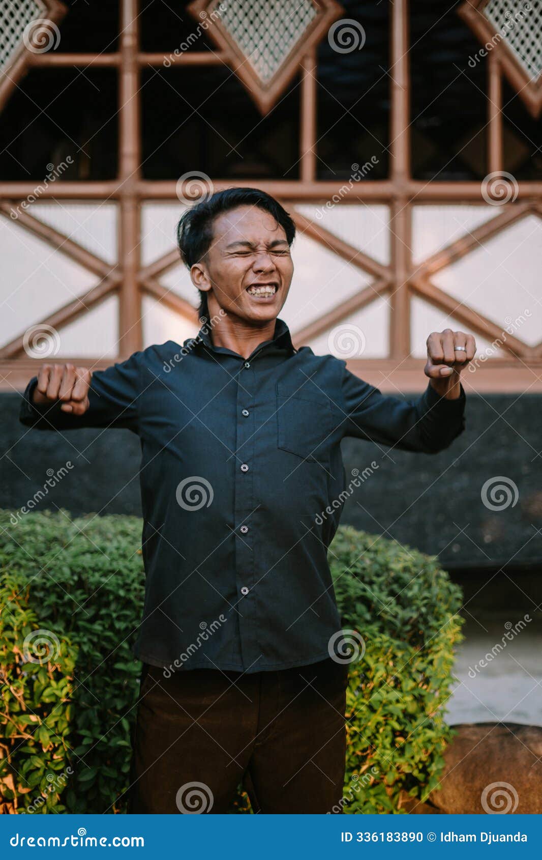 A Southeast Asian Man is Stretching His Back while Pushing His Hips ...