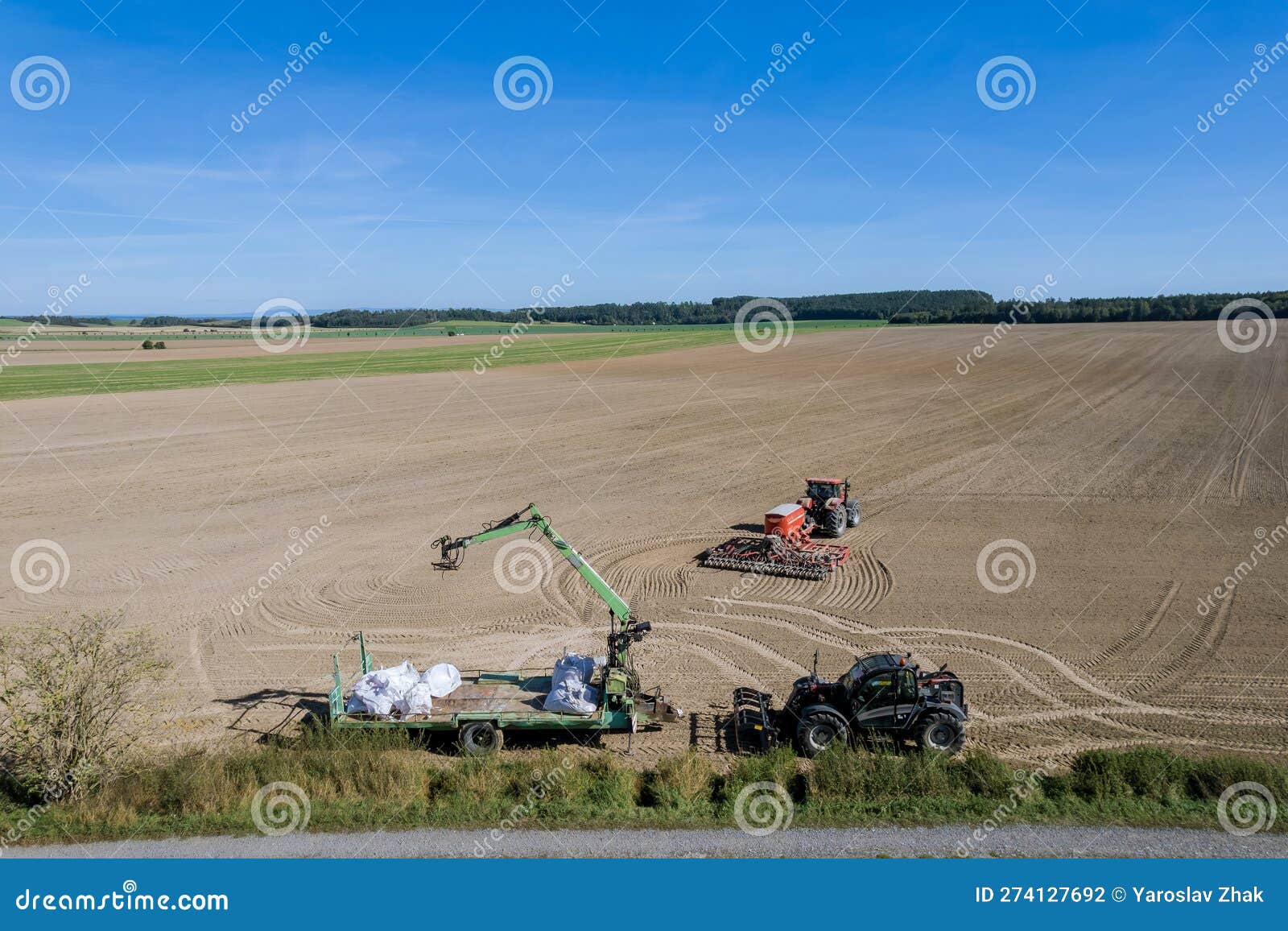 Sowing Grain in the Field, the Tractor Sows Grain with the Help of a ...