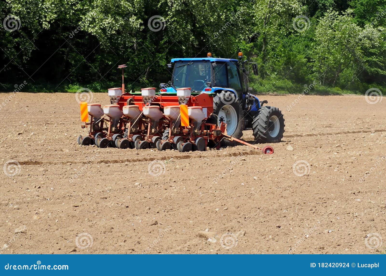 Sowing Seeds Machine Trailed by Tractor on a Plowed Field in Springtime ...