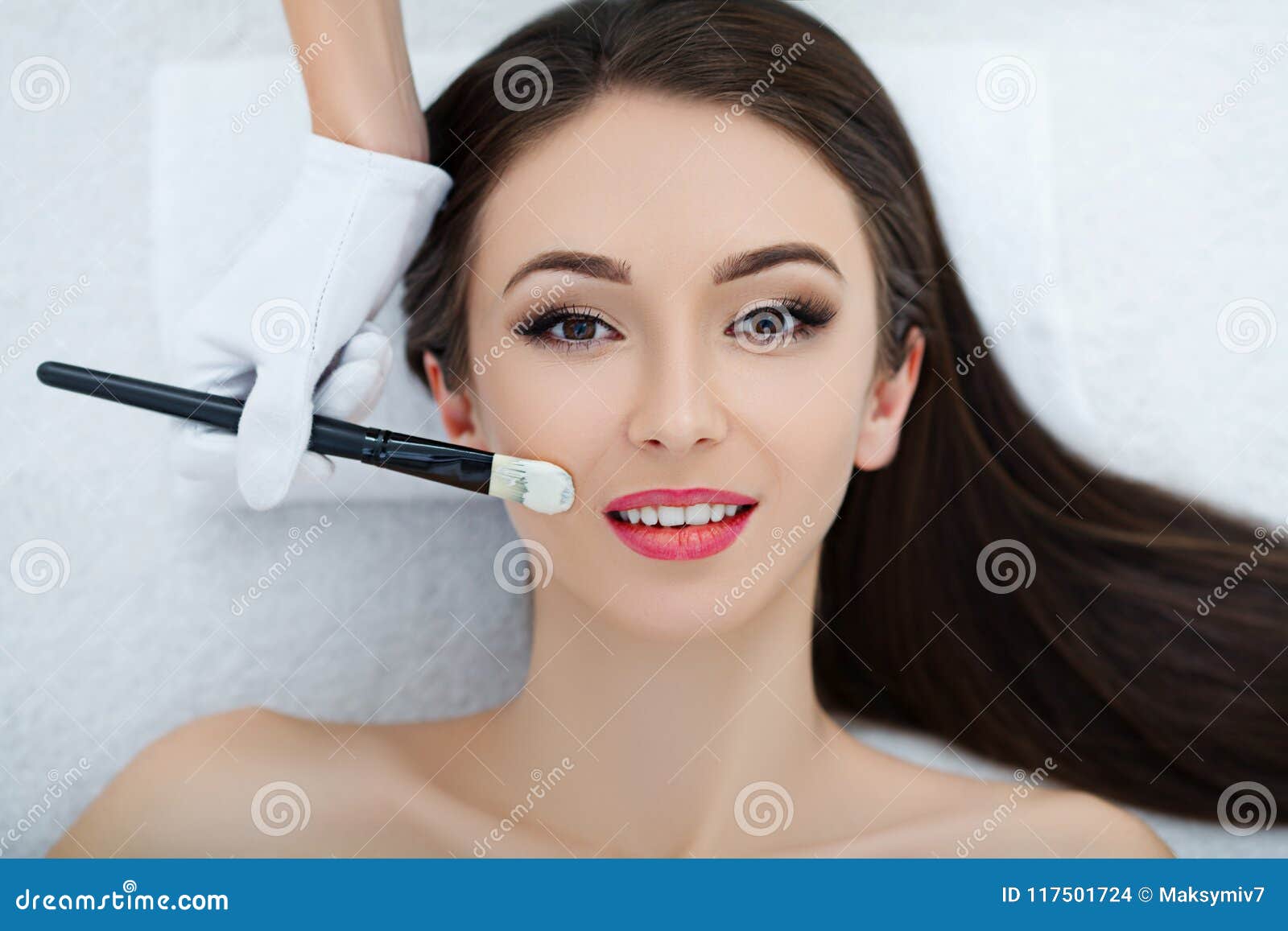Spa Beautician Applies The Mask To The Face Of Beautiful Young Stock