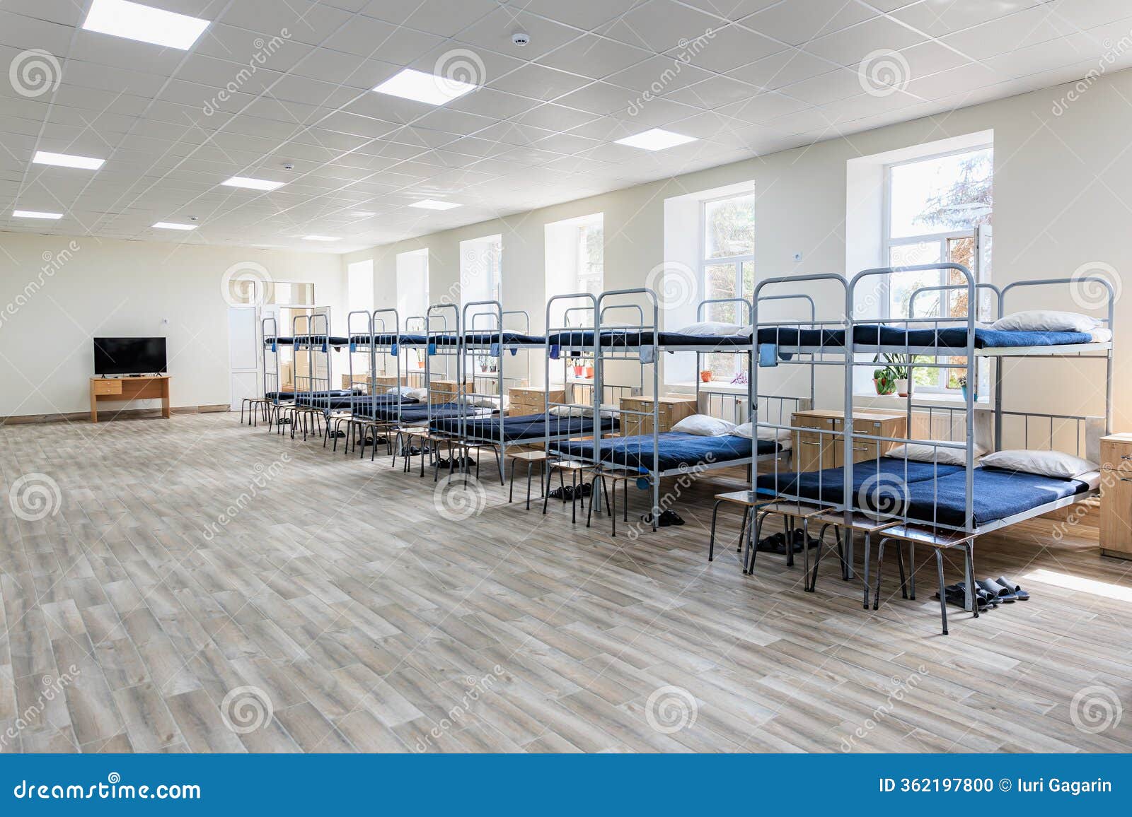 Spacious Dormitory Room with Rows of Bunk Beds and Bright Natural Light ...
