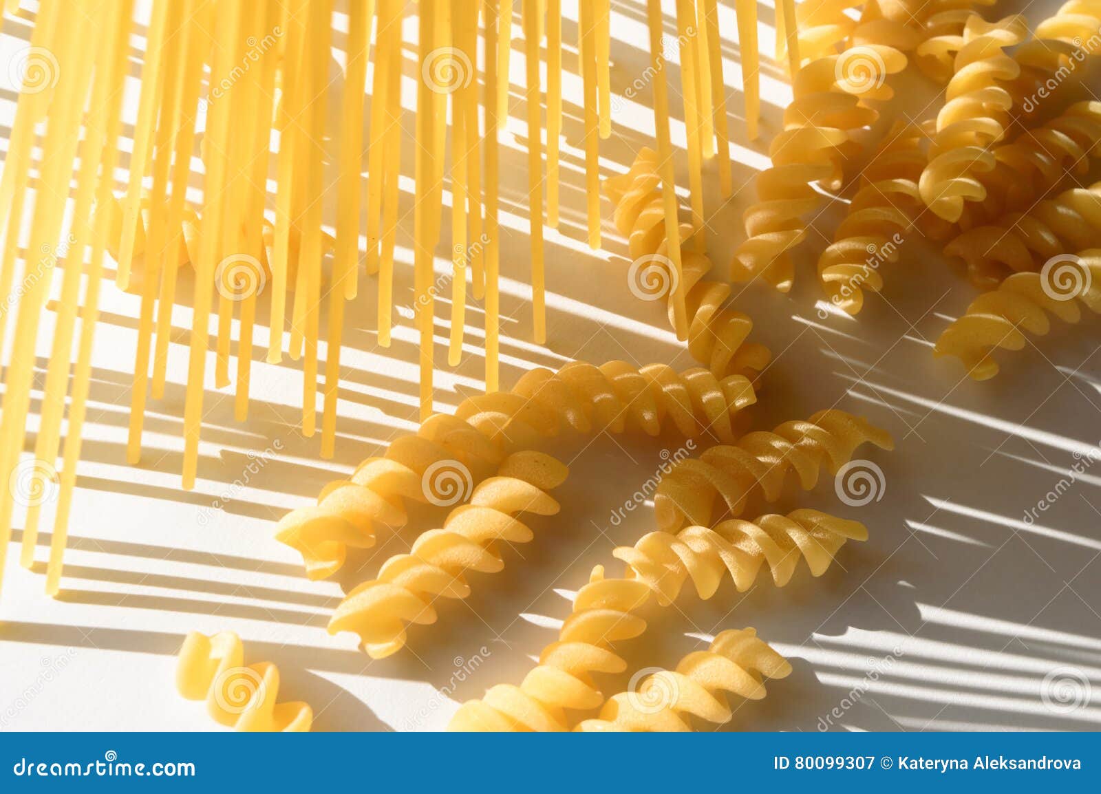 Spaghetti, Fusilli in Sun Light on White Table Stock Image - Image of ...