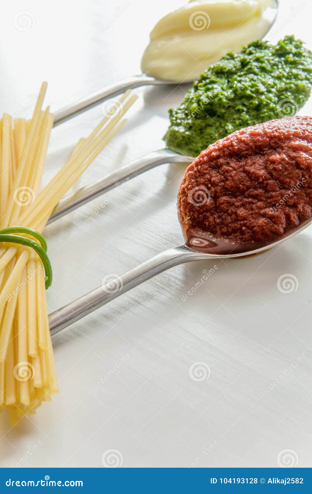 Spaghetti and Three Spoons with Different Condiments Stock Photo ...