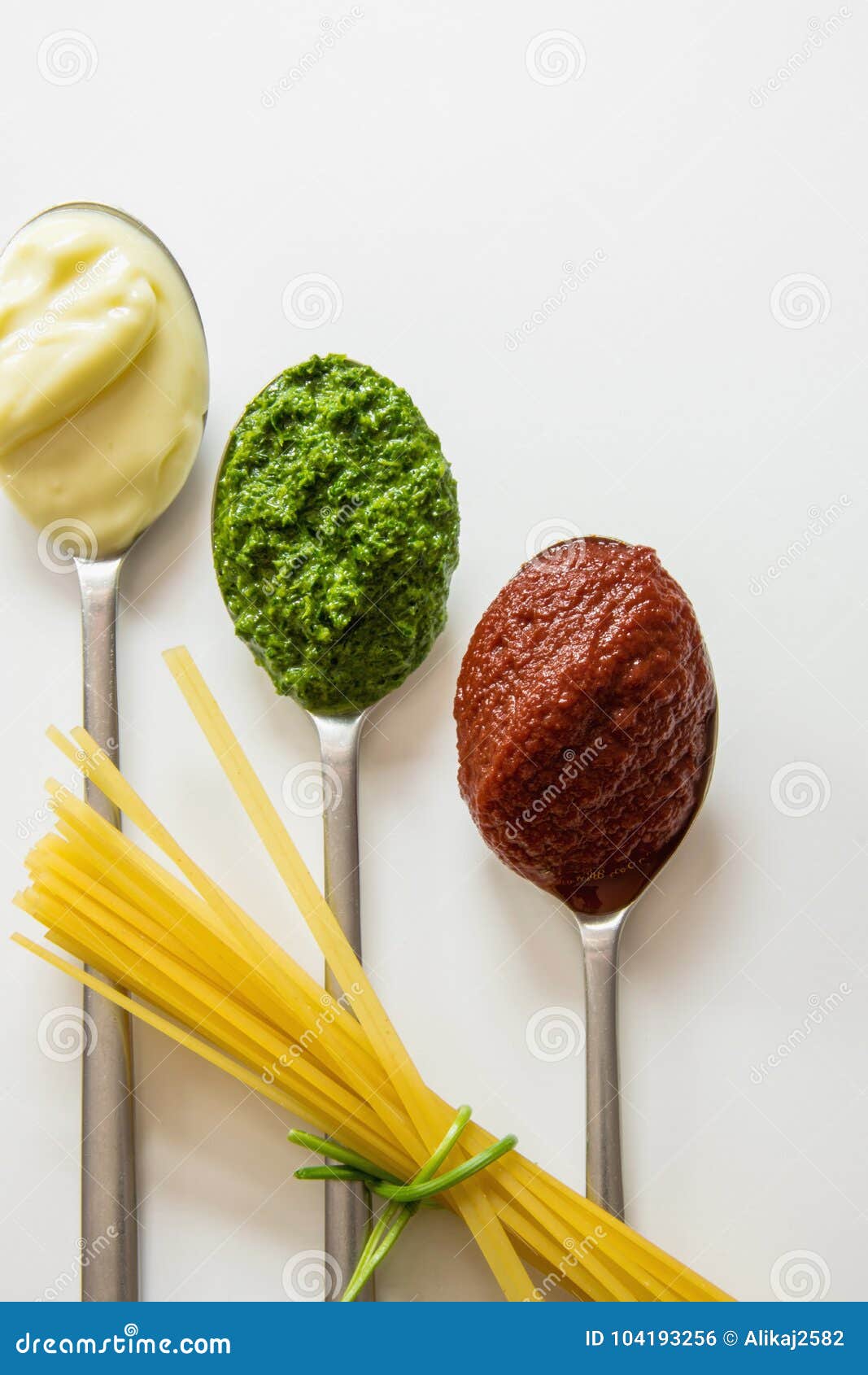 Spaghetti and Three Spoons with Different Condiments Stock Photo ...