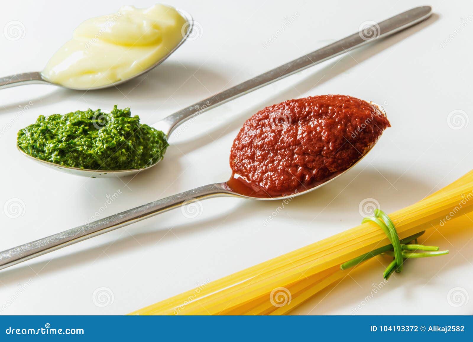 Spaghetti and Three Spoons with Different Condiments Stock Photo ...