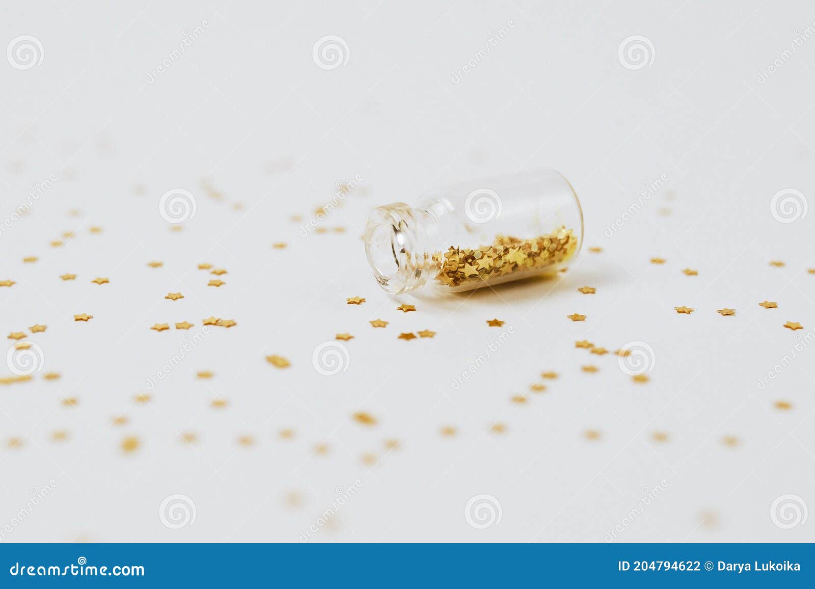Spangles of Gold are Scattered from Bottles on a White Background in a ...