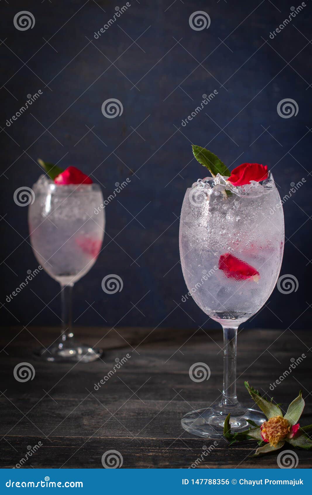 Sparkling Cold Water Detox with Rose and Ice on the Wood Table There is ...