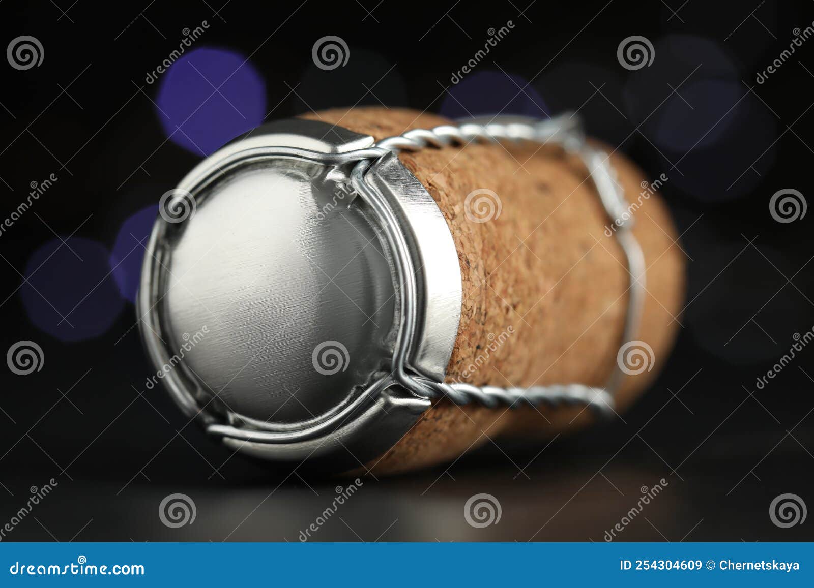 Sparkling Wine Cork with Muselet Cap on Table Against Blurred Festive ...